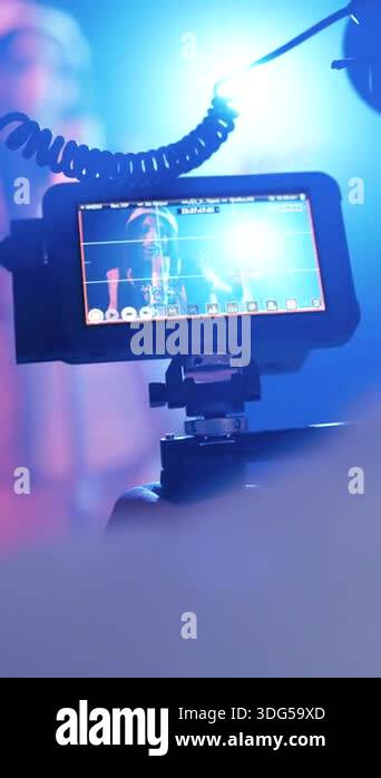 Behind the scenes look at a film set. Videographers hand holds a camera ...