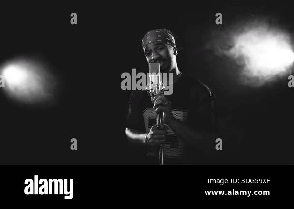 Black and white scene of a talented male rapper passionately singing ...