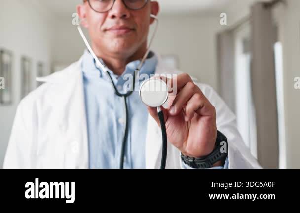 Friendly male doctor, wearing a white lab coat and glasses, smiles ...