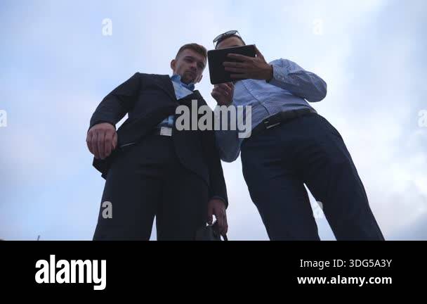 Low angle view of young businessman showing a presentation on screen of ...