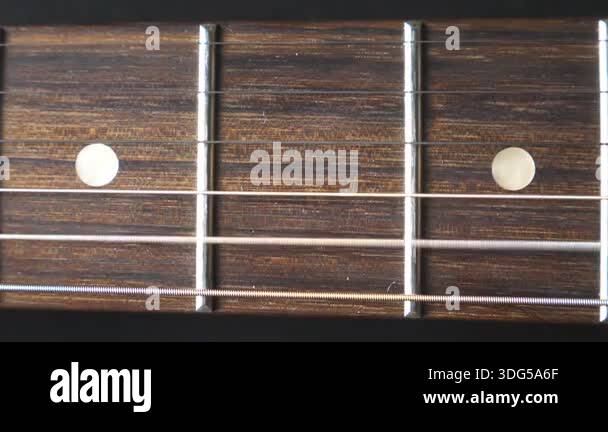 Close up of trembling guitar strings against fret. Chords being ...