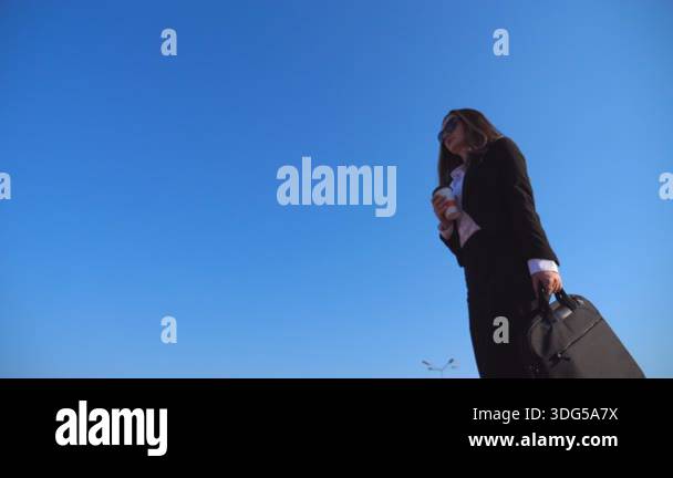 Young businesswoman walking along urban street with beautiful landscape ...