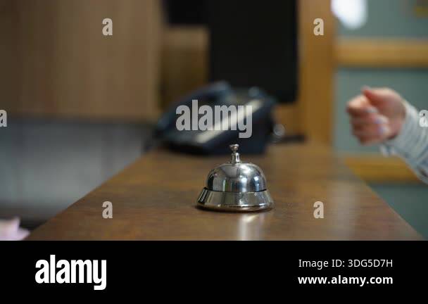 Man and woman shaking hands at a hotel reception desk, confirming a ...