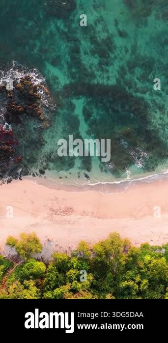 Incredible aerial top down view of a secluded pink sand beach with ...