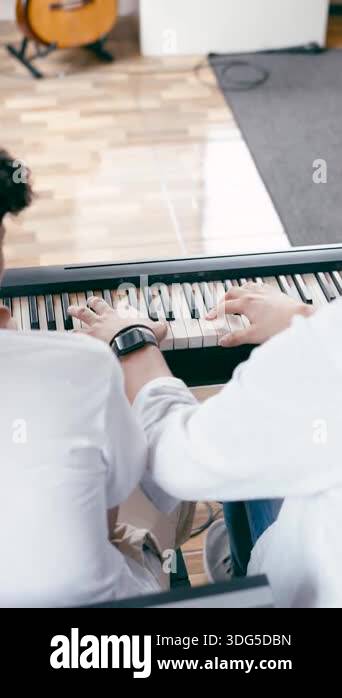 Music instructor teaching a young student to play the piano. Close up ...