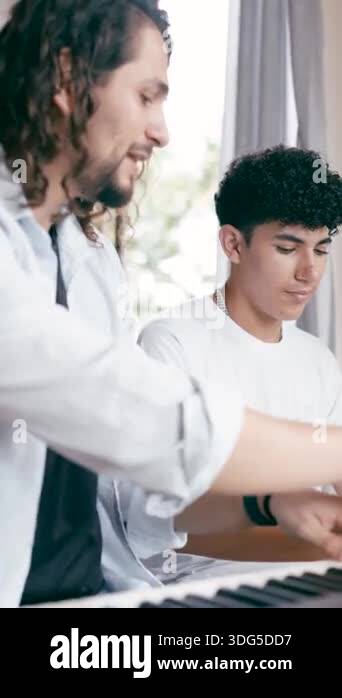 Young male student learning to play the keyboard with his private music ...