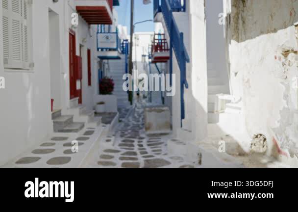 Mykonos narrow whitewashed street with soft bokeh and defocused sunlit ...