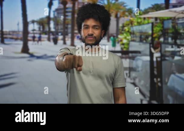 Man extending fist to camera on outdoor restaurant terrace with palm ...