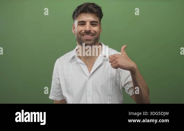 Man shows double thumbs up gesture in green studio setting with visible ...