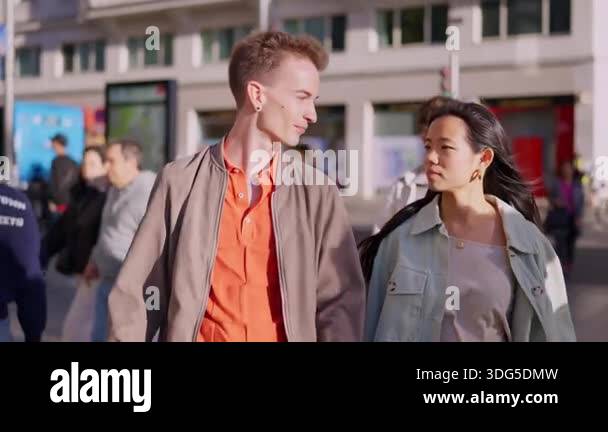 Young inclusive multiethnic couple walking together in the city during ...