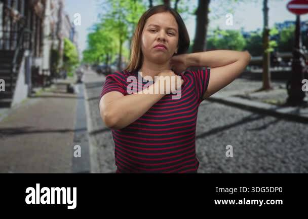 Young caucasian woman holding neck with hand and rubbing shoulder while ...