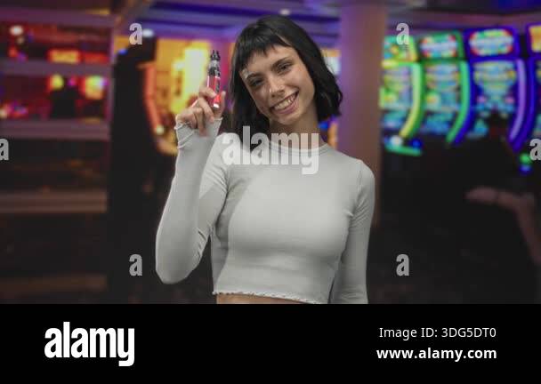 Smiling young woman holding vape with freckled face in colorful slot ...