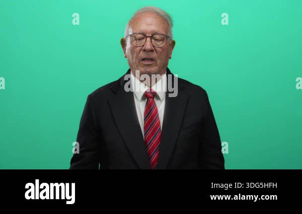 Senior businessman in suit with hand on heart and other raised, stands ...