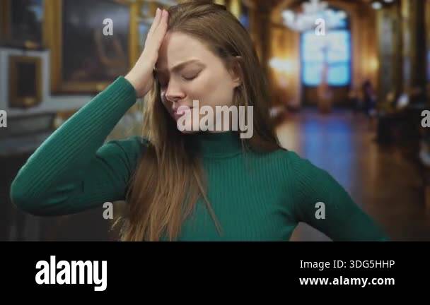 Young caucasian woman resting hand on forehead in museum building ...