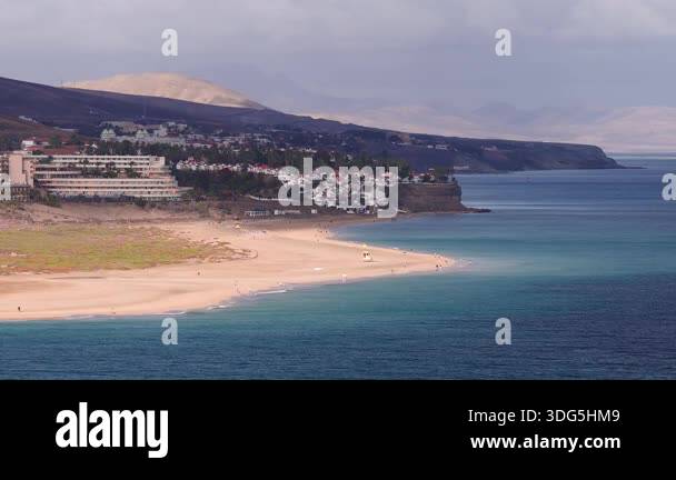 Aerial 4K view shows Fuerteventura sandy spit, turquoise bay, resort ...