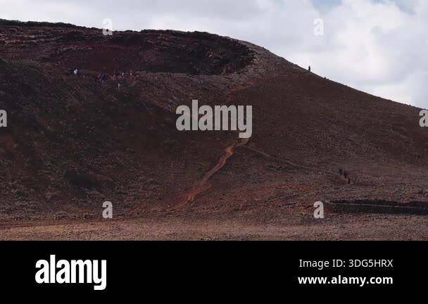 Aerial view of a large volcanic crater on Fuerteventura. Hikers move ...