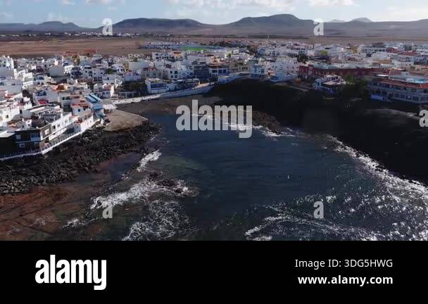 Aerial high angle over a whitewashed coastal town in Fuerteventura, a ...