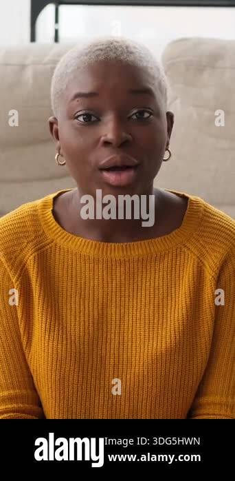 Happy African American woman with short hair talking and smiling at the ...