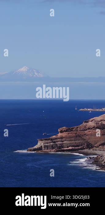 Aerial daytime view of Gran Canaria's rugged coast, marina on right ...