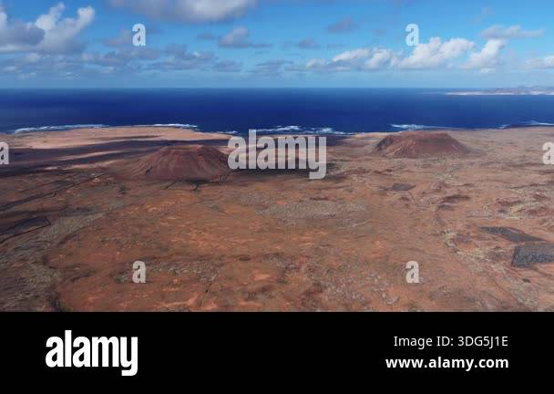 Aerial 4K pan shows Fuerteventura cinder cones, rust plain, Atlantic ...