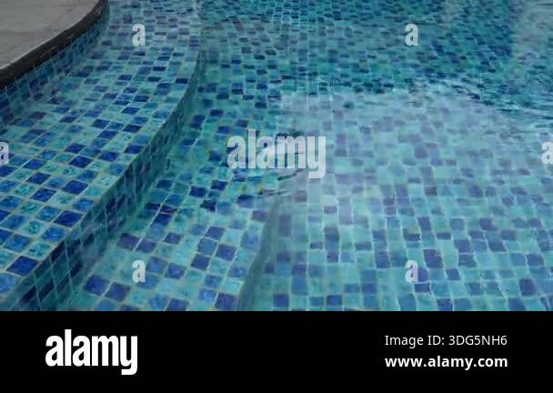 Footage of clear blue swimming pool water with gentle ripples flowing ...