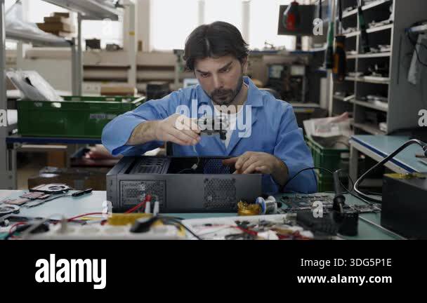 A man is diligently repairing computer, engaged in tasks that require ...