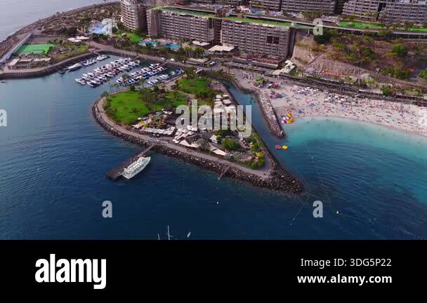 Aerial view shows a triangular man made peninsula, cabanas, palm trees ...