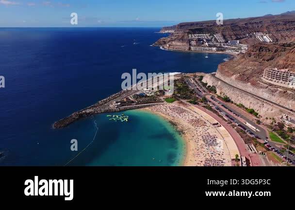 Aerial view shows Playa de Amadores, Gran Canaria, golden sand, rock ...