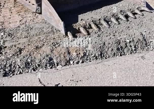 Heavy tractor machinery digs prepares road surface with gravel concrete ...