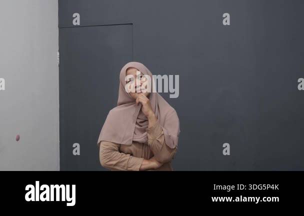 Asian muslim woman thinking something with smile on her face, happy ...
