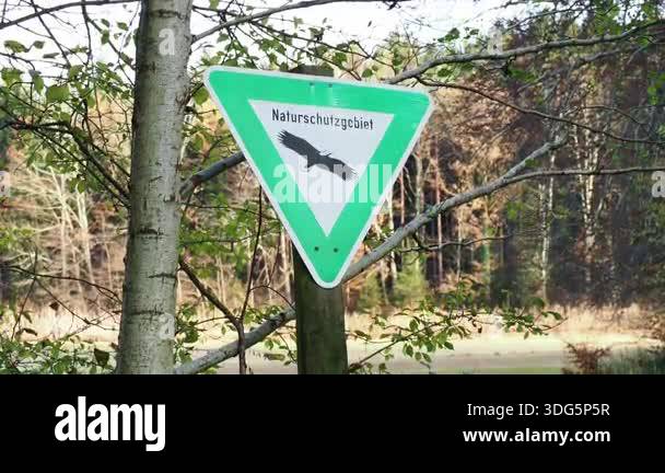 A sign with the German text Naturschutzgebiet stands at the entrance of ...