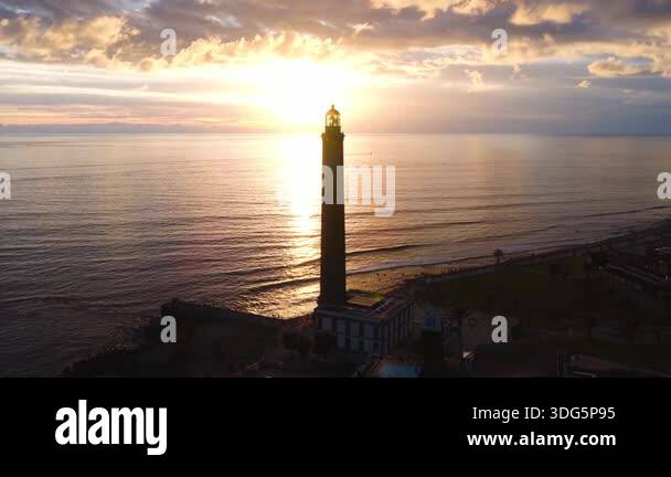 Aerial view shows Maspalomas Lighthouse, promenade, palm trees, and ...