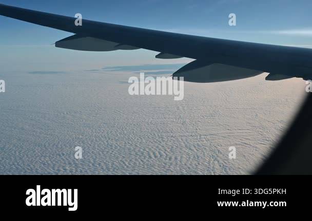 View from an airplane window showing the aircraft wing flying above a ...