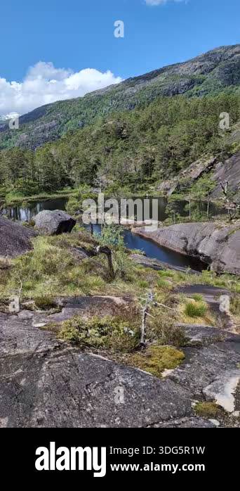 High angle view showing small calm lake nestled between large grey ...