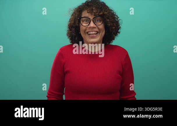 Woman with curly hair wearing red sweater and glasses holds hands on ...