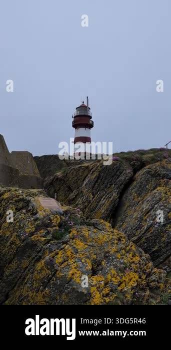 Low angle view of tall red and white striped lighthouse tower standing ...
