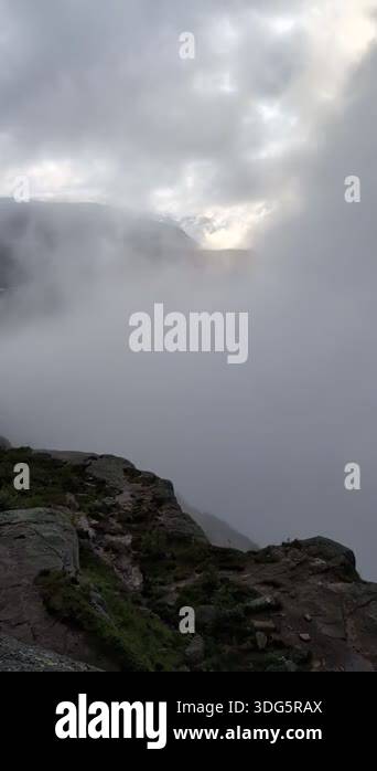 A mysterious, atmospheric view shows thick, swirling white fog ...