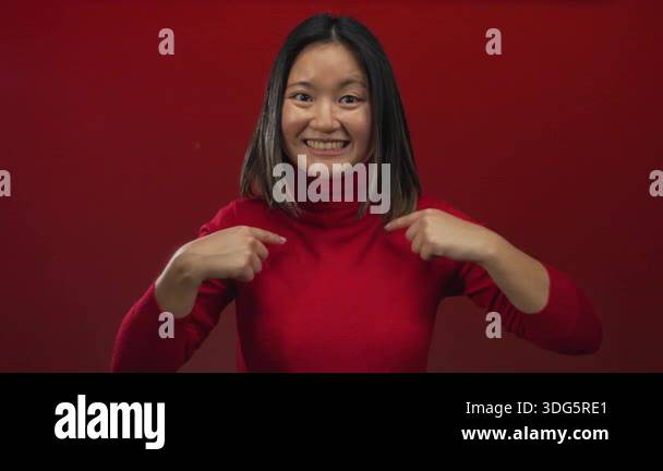 Woman in red sweater smiling and pointing to herself against a vibrant ...