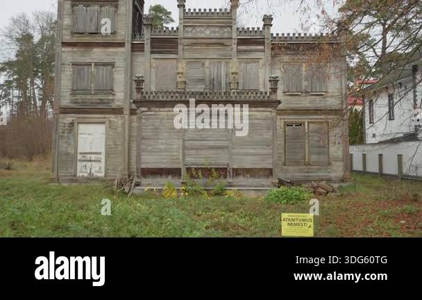 Neglected wooden villa building with boarded windows and doors in ...