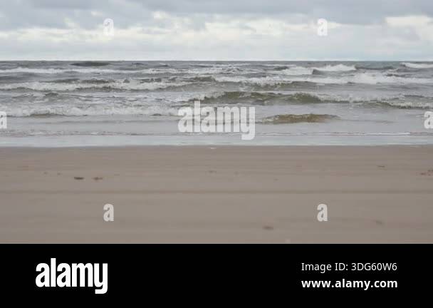 Sea waves rolling on sandy beach of Baltic Sea in Jurmala Latvia. Low ...