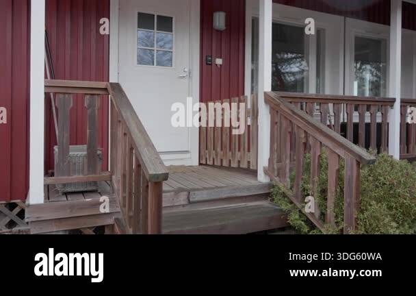 Entrance of traditional red wooden house in Finland with white door and ...