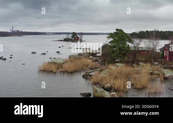 Red wooden houses on two separate rocky islands in Finland archipelago ...