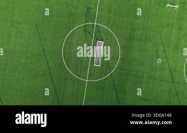 Top view aerial rotation over empty football pitch, clean green lines ...