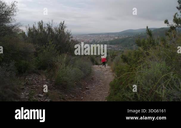 A woman runs up the mountain along a rocky path Stock Video Footage - Alamy