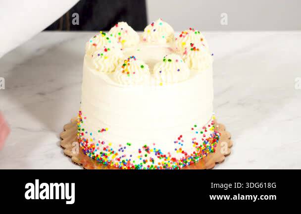 A full round vanilla birthday cake topped with swirl frosting and ...