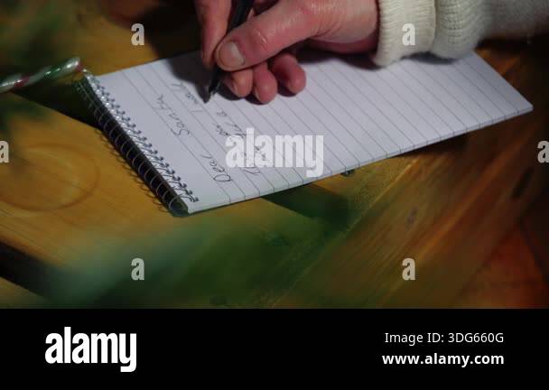 Writing a letter to Santa on notepad view through Christmas tree close ...