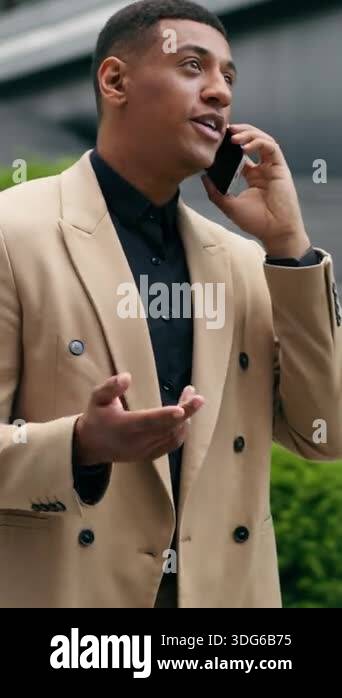 African American business man talking on mobile phone in city street ...