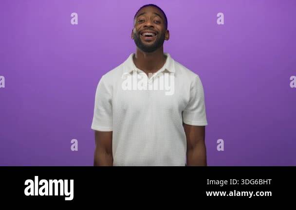 Man smiling and showing braces with a head tilt in studio with purple ...