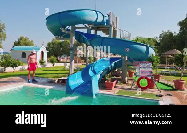 Beautiful view of blue water slide flowing into resort swimming pool ...