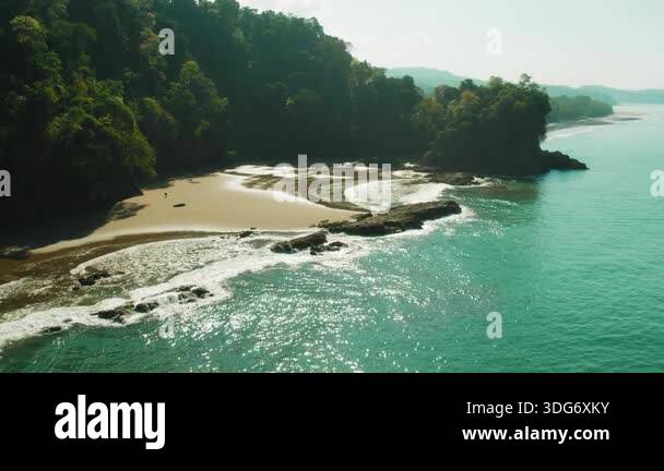 Quiet cove with ocean waves touching a sandy shore in Playa Arco Costa ...